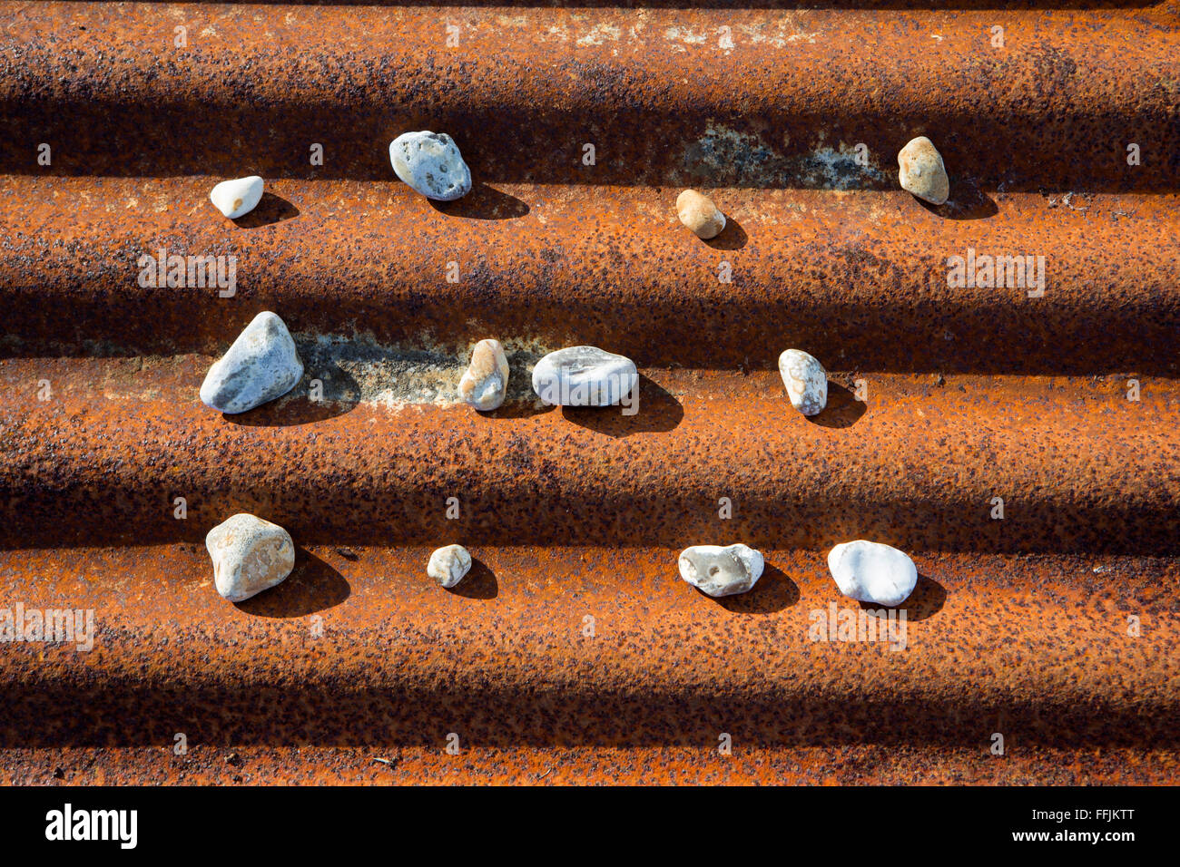 A sheet of rusty corrugated iron with pebbles Stock Photo - Alamy