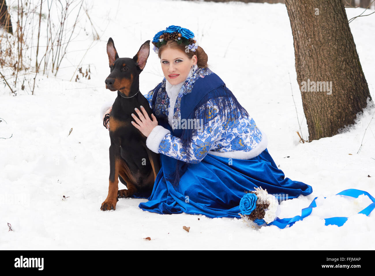 Young russian woman in traditional winter clothing with Doberman ...