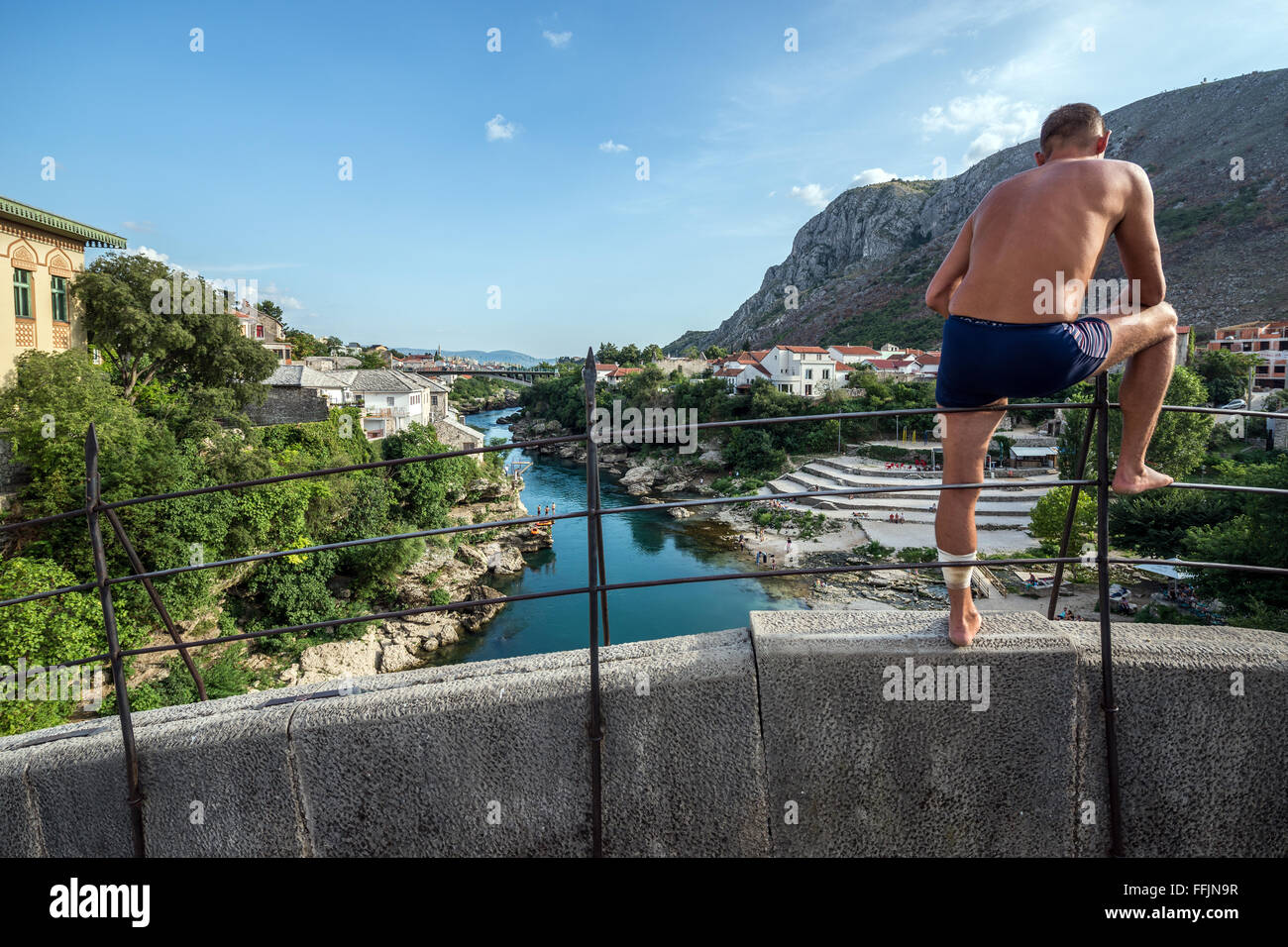 Diver standing on Stari Most (Old Bridge), Old Town of Mostar city ...