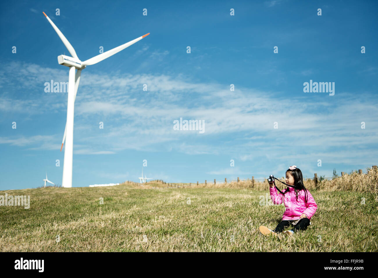 Blue sky and wind turbines, children peacefully holding a camera ...