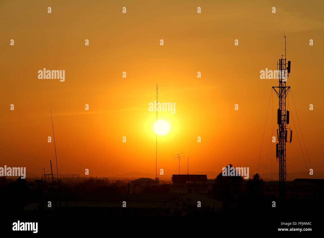 Silhouette of telecommunication tower in golden sunset background Stock ...