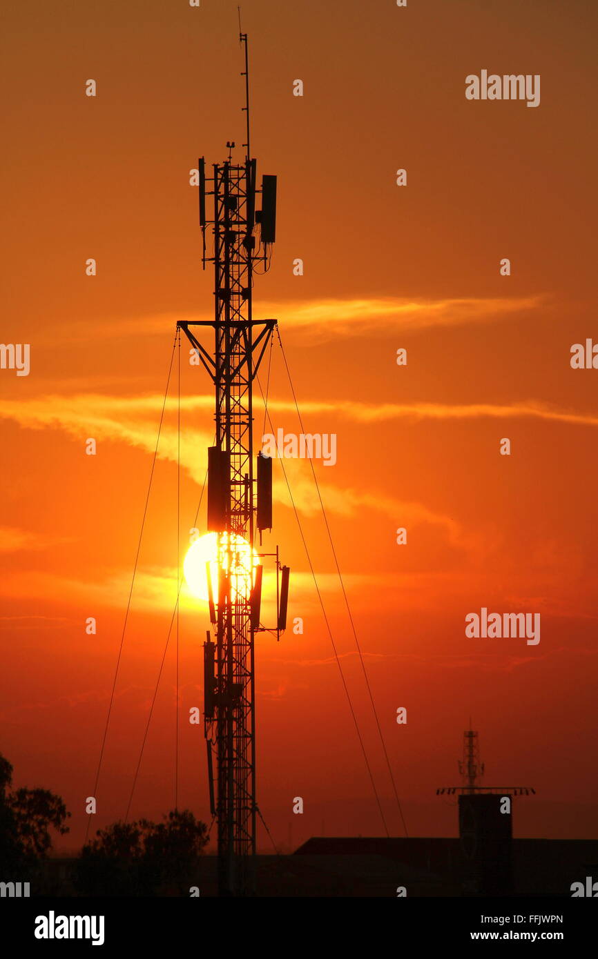 Silhouette of telecommunication tower in golden sunset background Stock Photo - Alamy