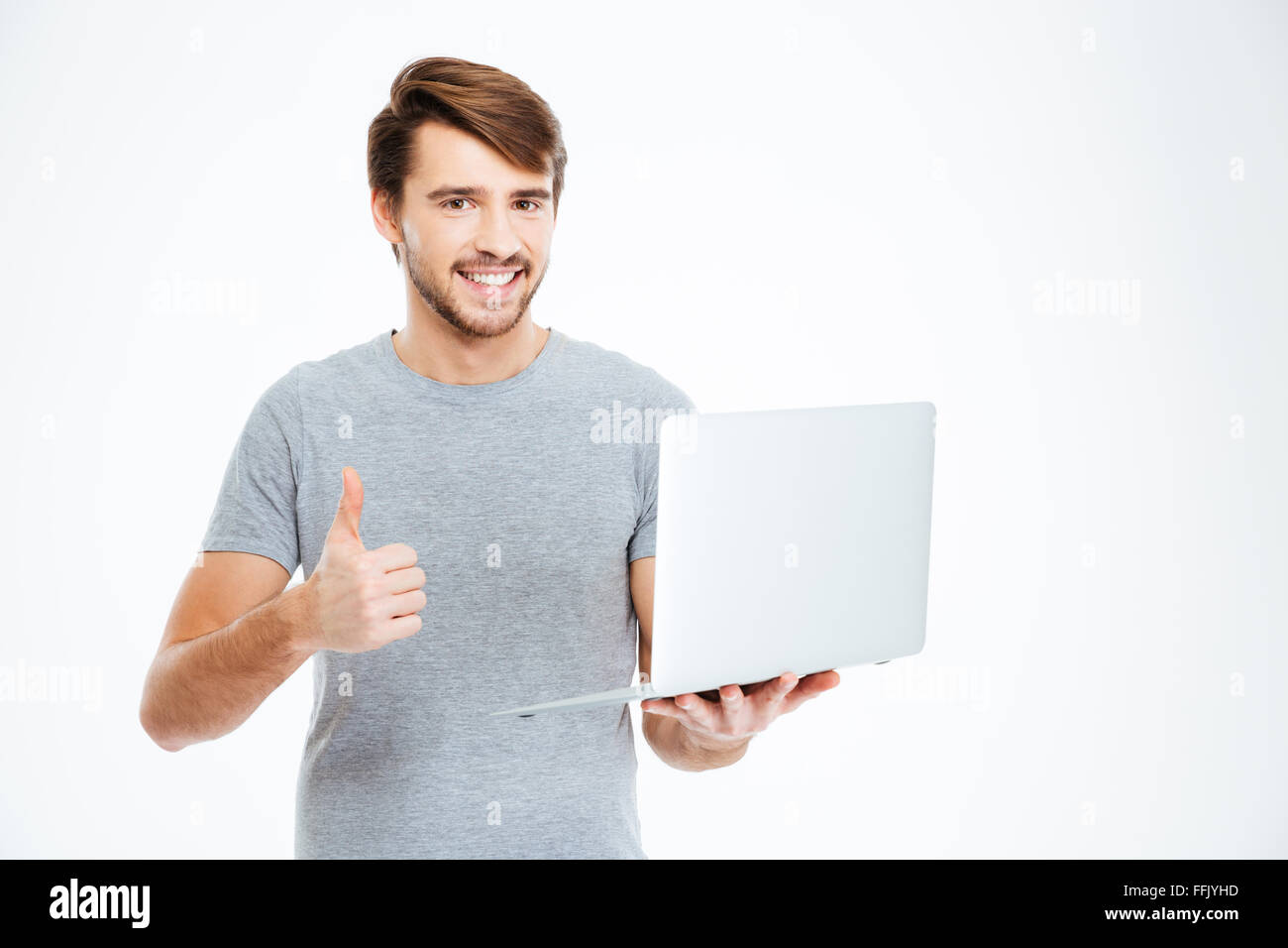 Smiling casual man holding laptop computer and showing thumb up ...