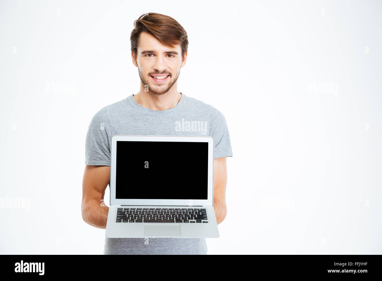 Smiling handsome man showing blank laptop computer screen isolated on a ...