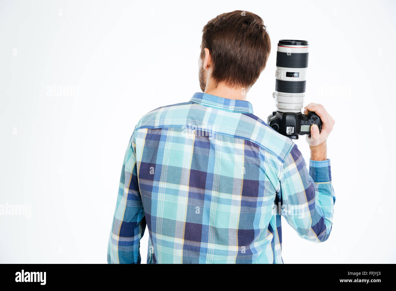 Back view portrait of a male photographer holding photo camera isolated ...