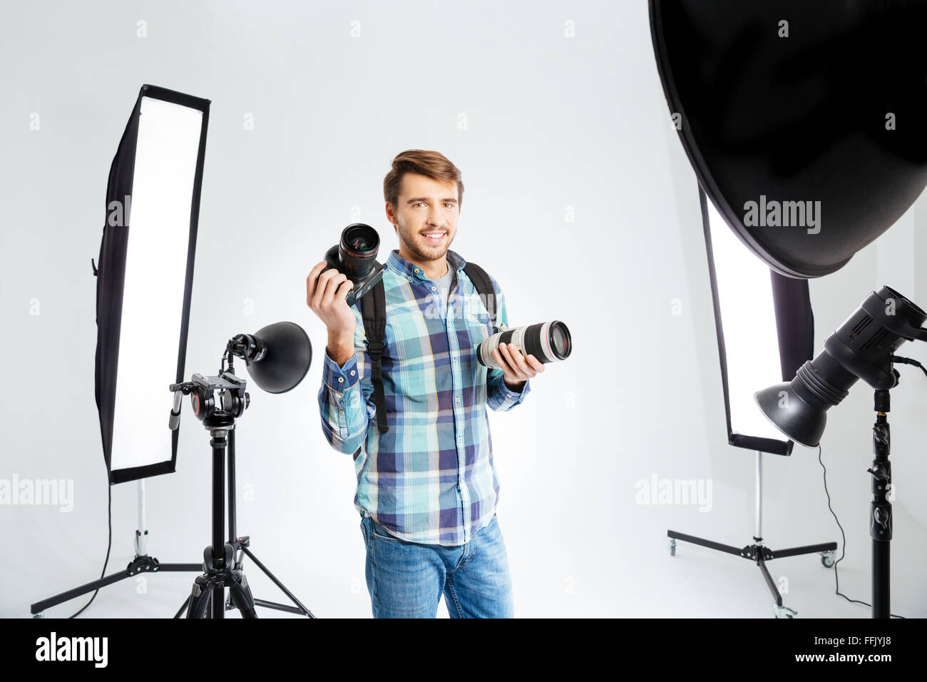 Happy male photographer standing in photo studio with equipments Stock ...
