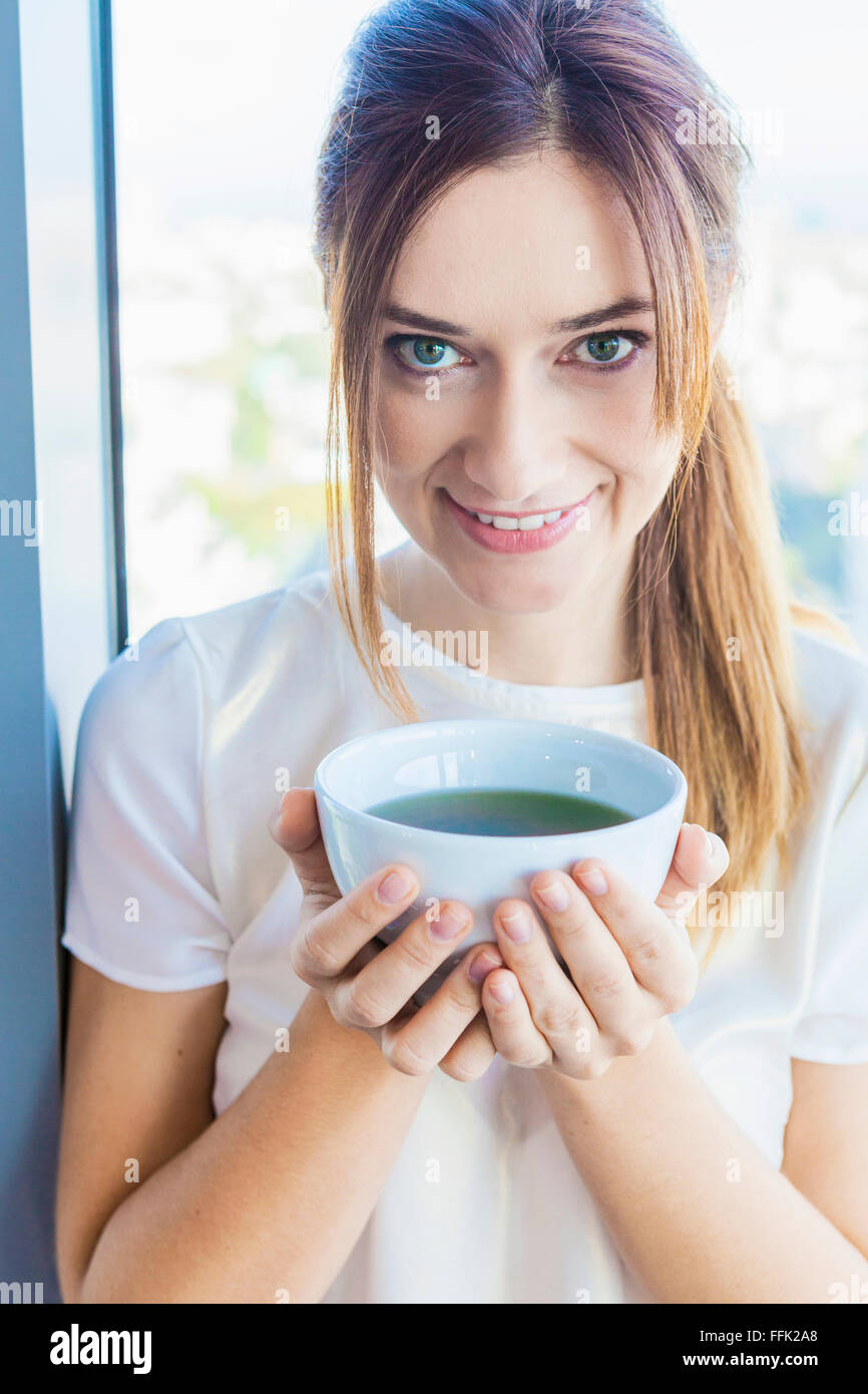 Woman in apartment takes a break holding tea cup Stock Photo - Alamy