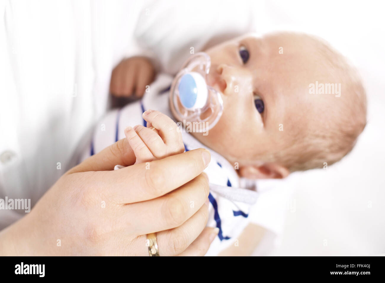 A woman holds in her arms her newborn baby . Little man, baby clinging ...