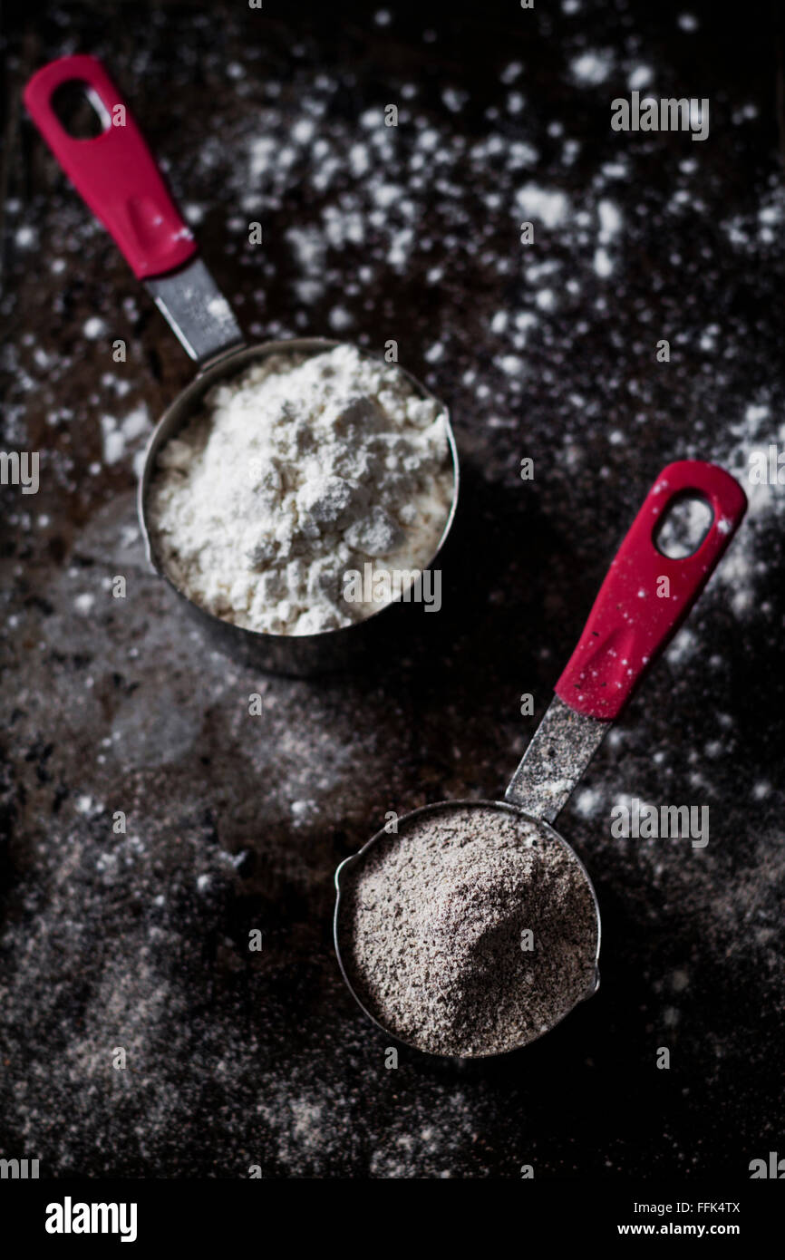Wheat and buckwheat flour in measuring cups on a vintage pan Stock ...