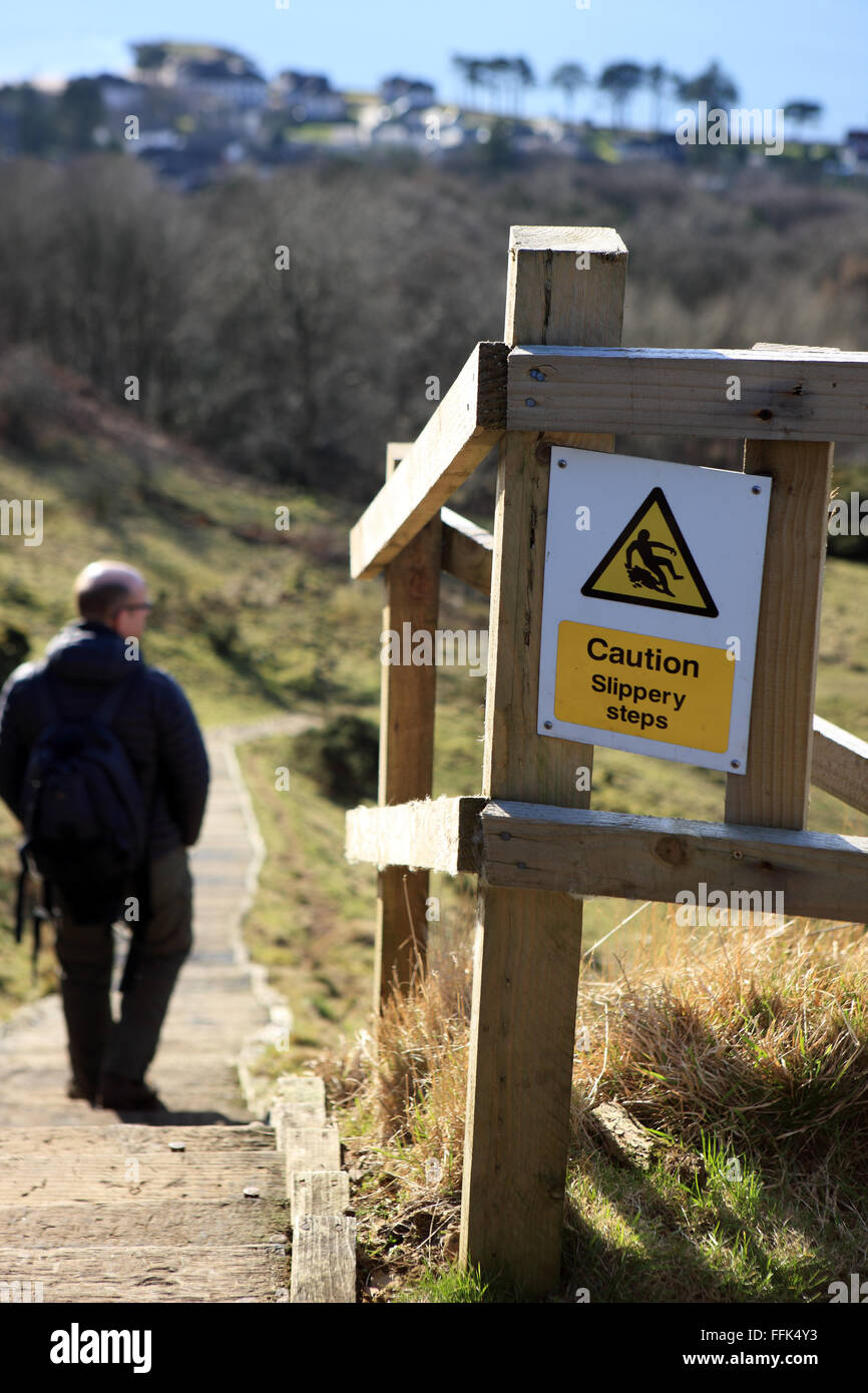 'Caution Slippery Steps' sign at the top of steep steps made out of ...