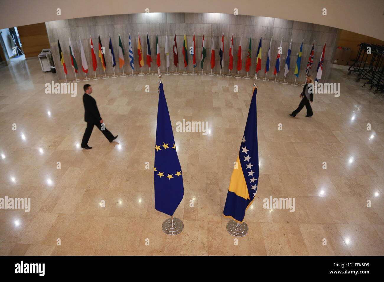 Sarajevo, BiH. 15th Feb, 2016. People walk in front of flags of EU and ...
