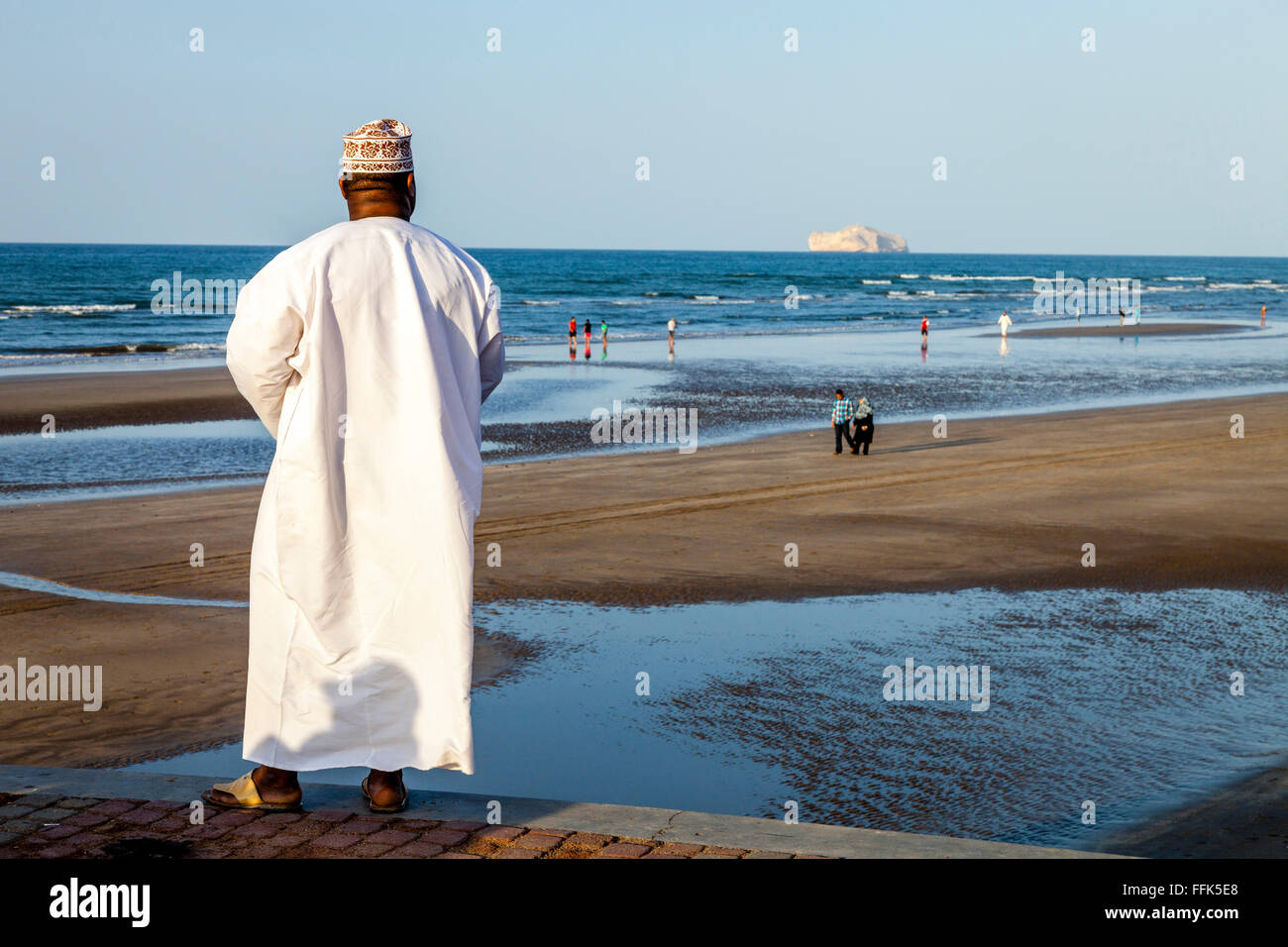 An Omani Man In Traditional Dress Looks Out Over The Beach At Muscat ...
