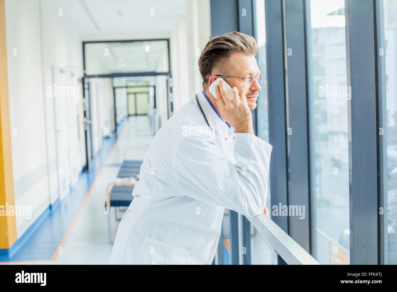 Doctor in medical clinic using mobile phone Stock Photo - Alamy