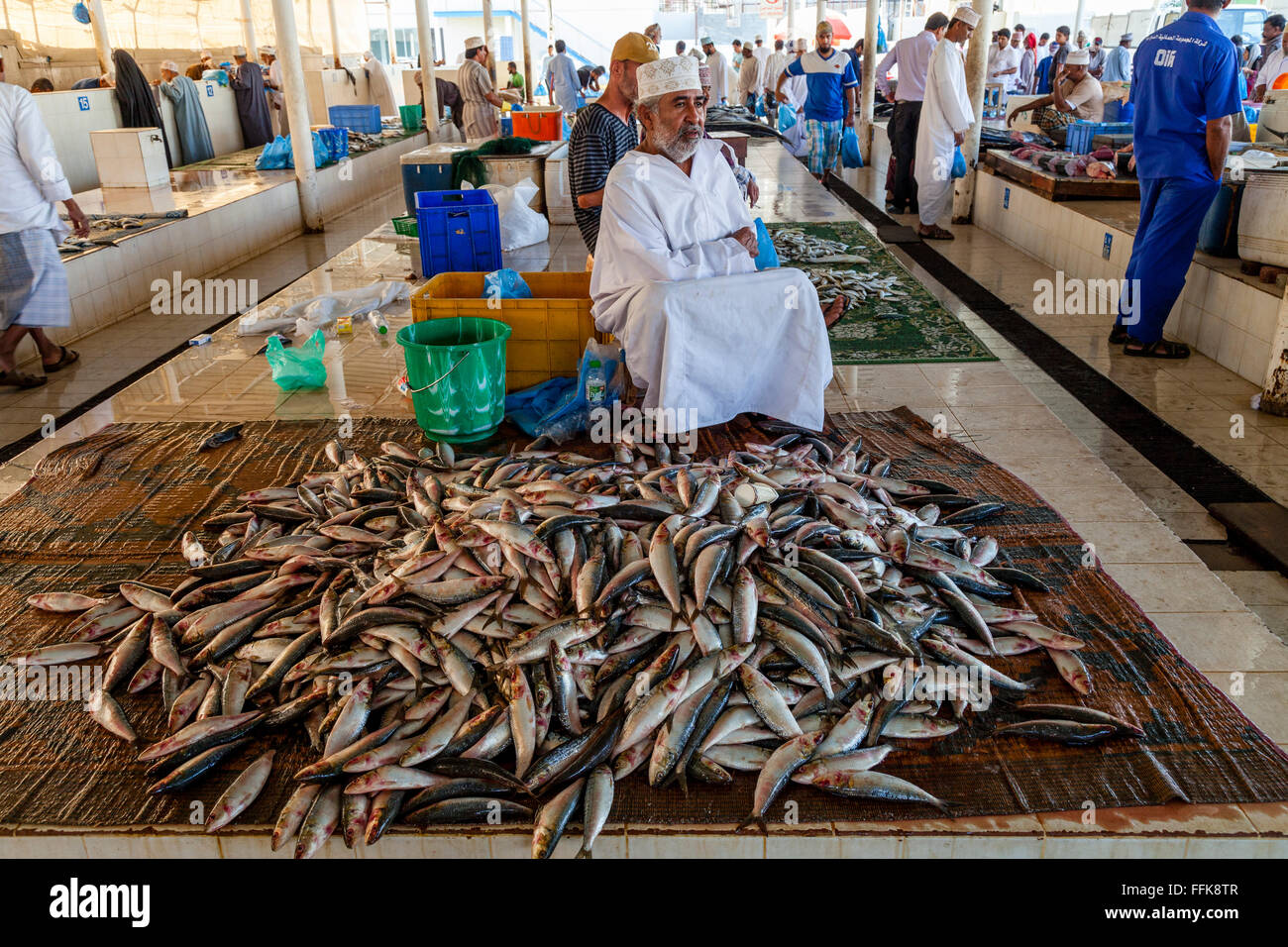 An Omani Man In Traditional Dress Sells Fish At The Fish Market ...