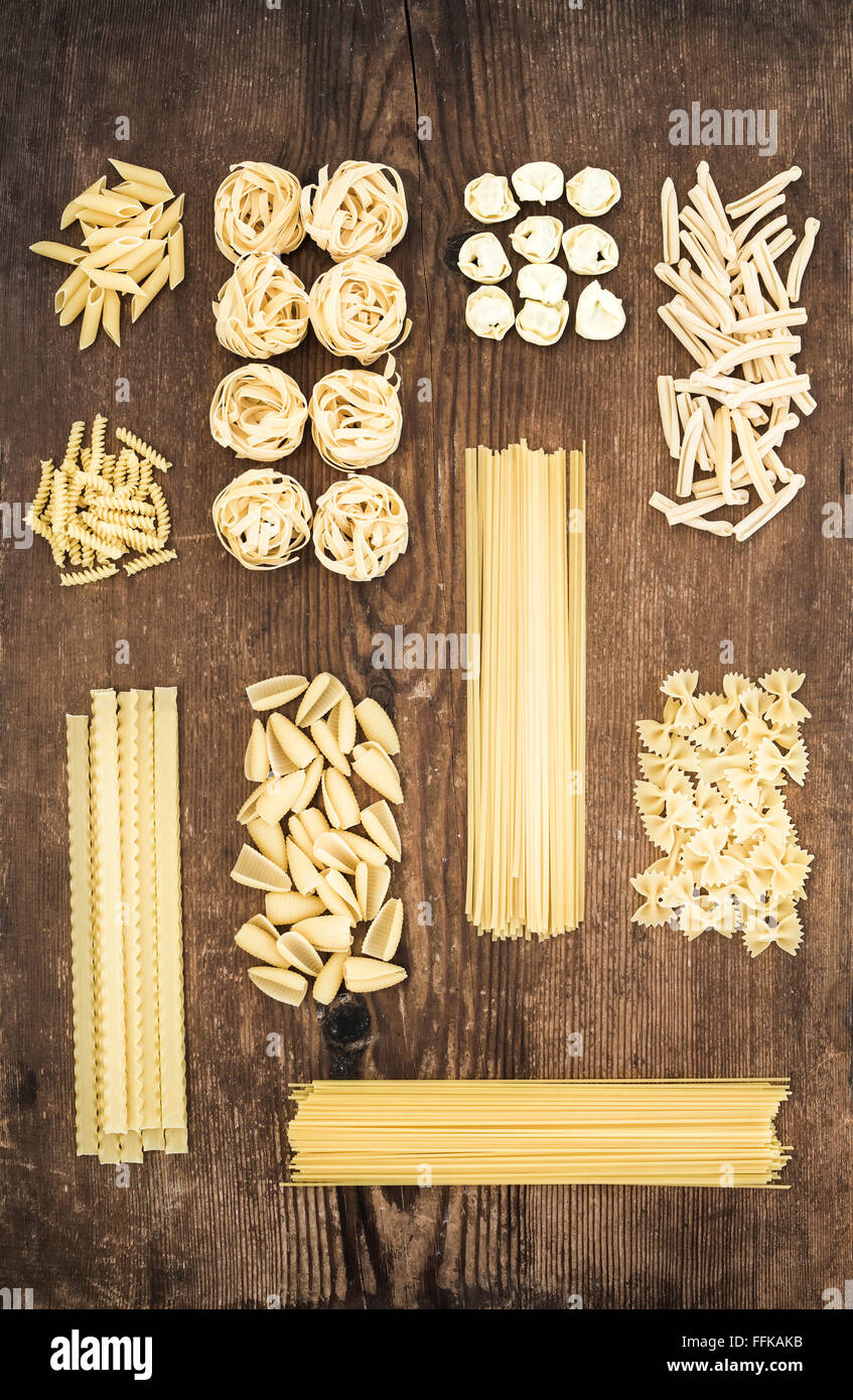 Different types of Italian uncooked pasta on rustic wooden table ...