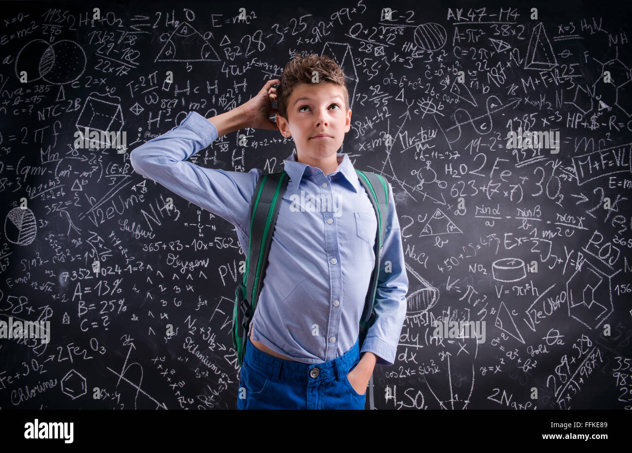 Boy thinking, scratching his head, blackboard with mathematical Stock ...