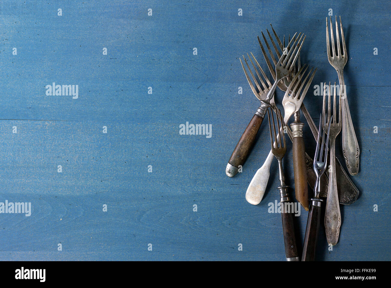 Set of vintage forks over blue wooden surface. Top view Stock Photo - Alamy