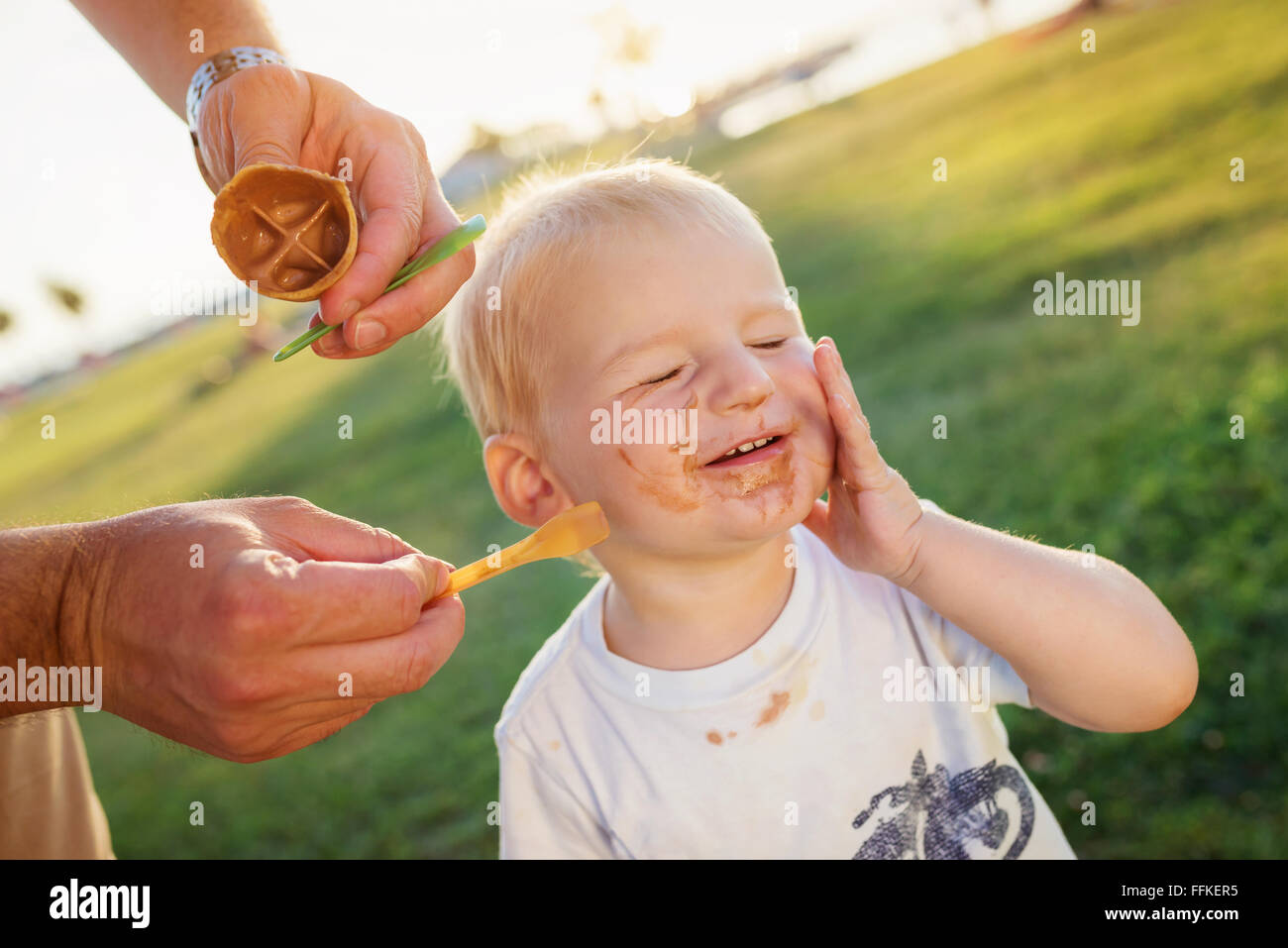 Boy eating ice cream, dirty face, green meadow, sunny Stock Photo - Alamy