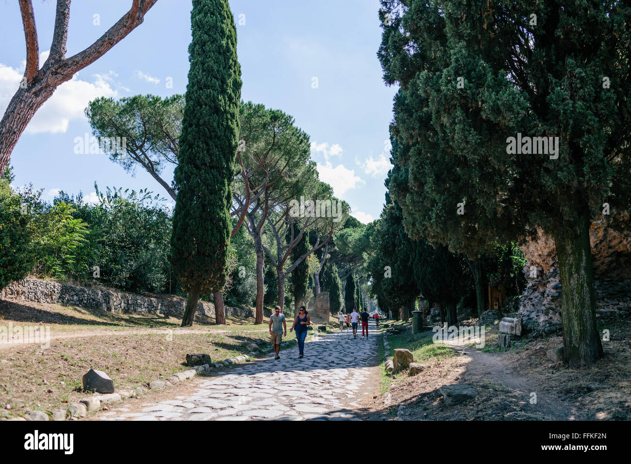 Tourists walking along the Appian Way, a historical road and tourist ...