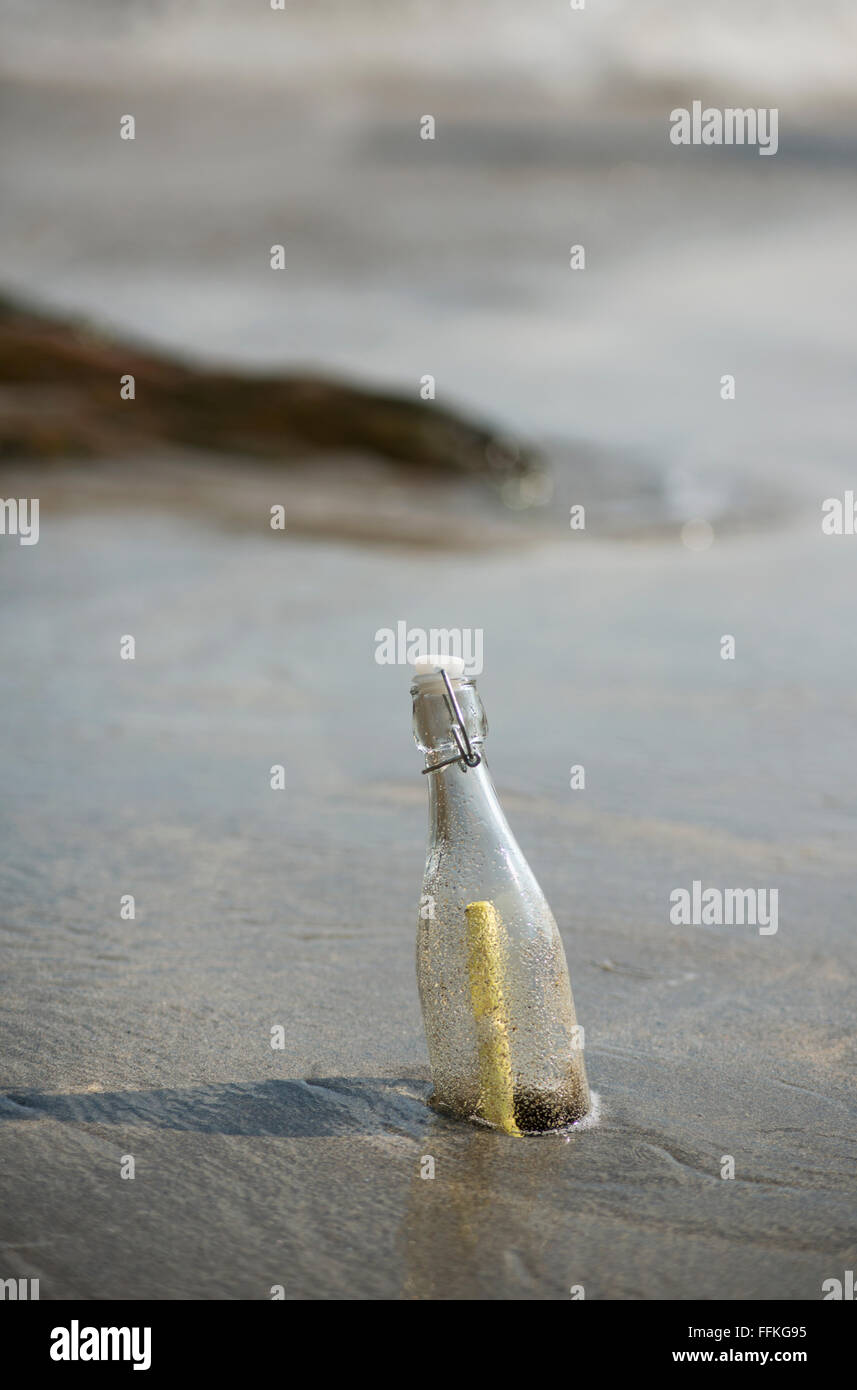 Message in a bottle washed up on a sandy beach Stock Photo - Alamy