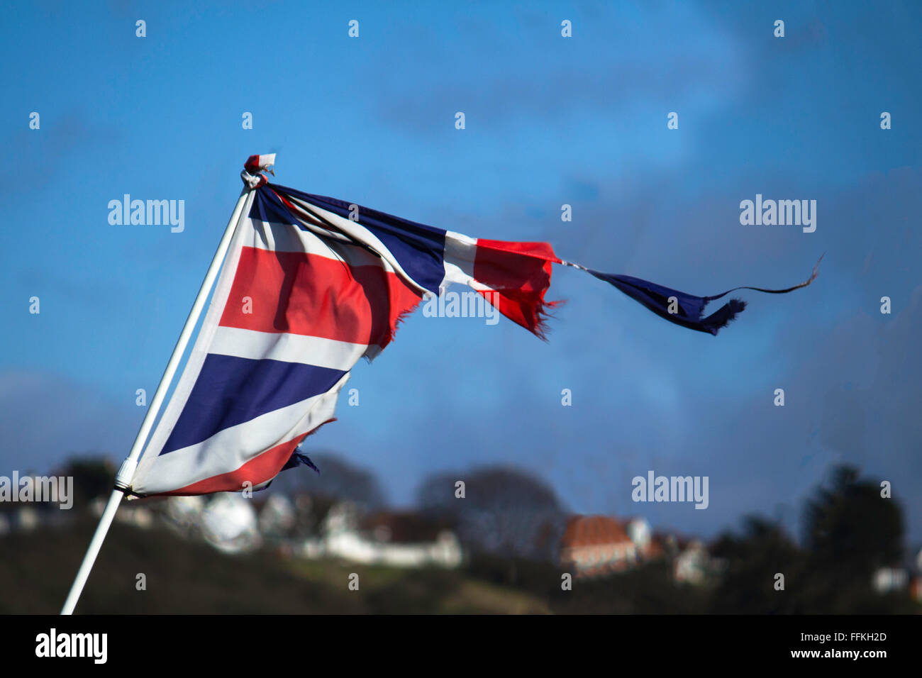 Ripped Union Jack on Blue Sky Stock Photo - Alamy