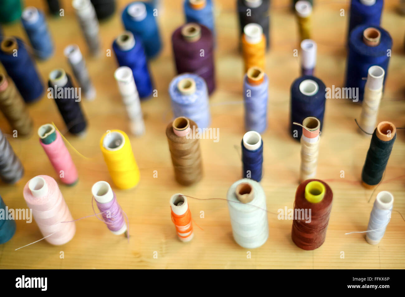 A high angle view of a large group of displayed bobbins of thread on a ...