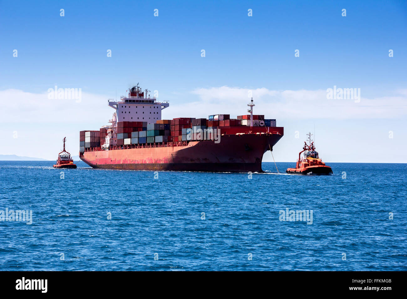Tugboats pulling container cargo ship to harbor Stock Photo - Alamy