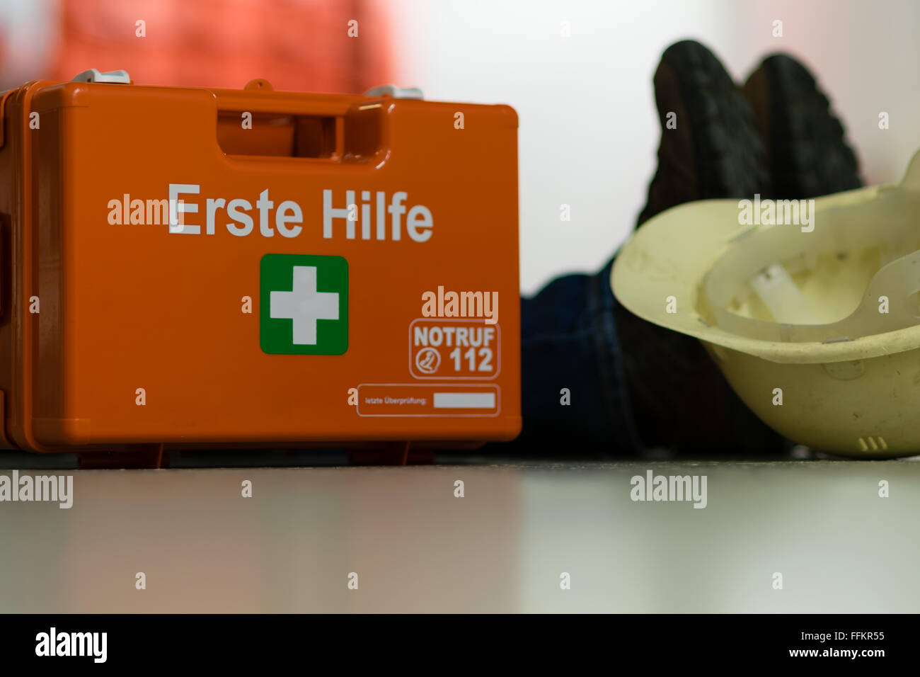 First aid after an accident at work. First aid kit and helmet near ...