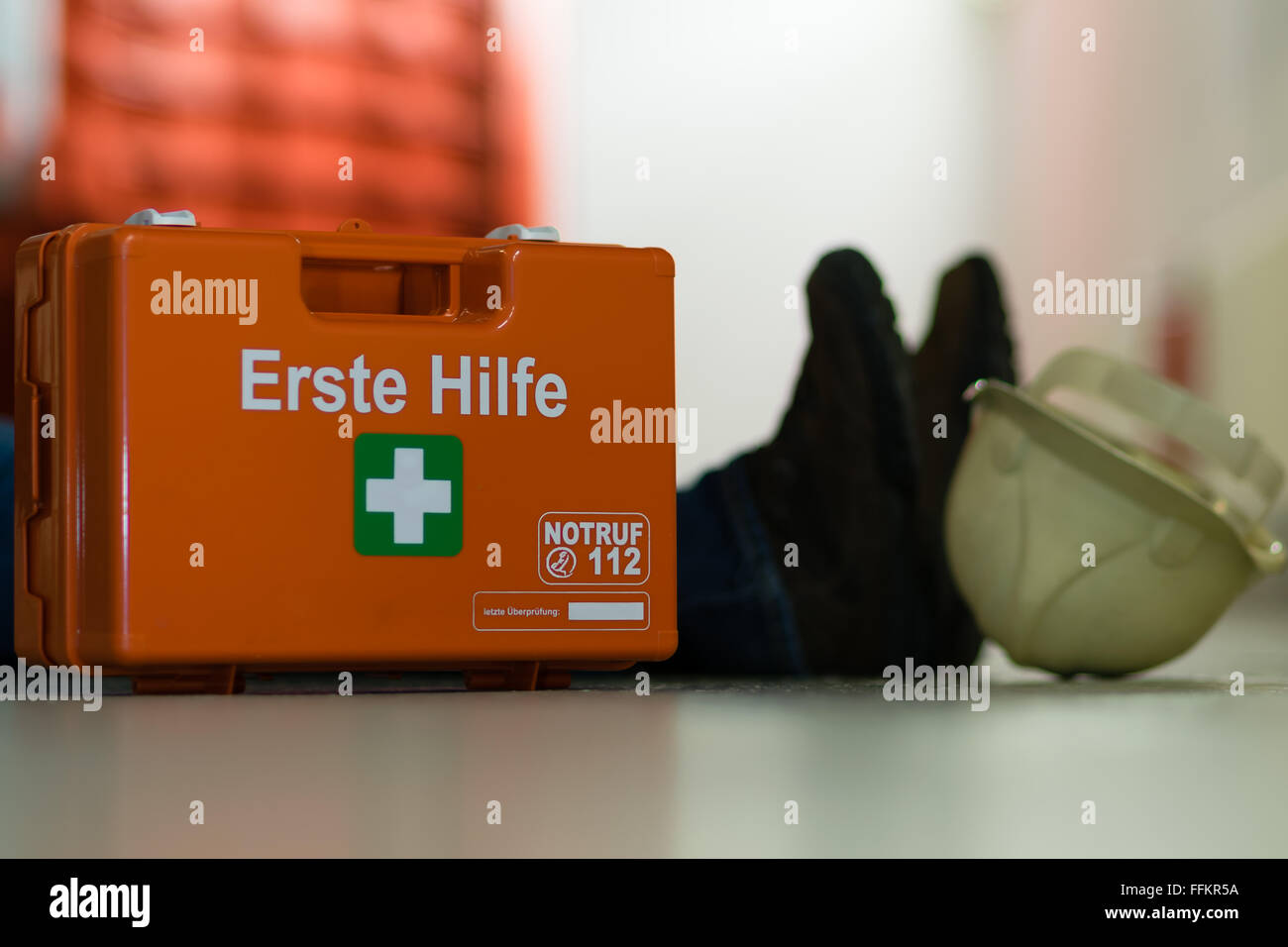 First aid after an accident at work. First aid kit and helmet near ...