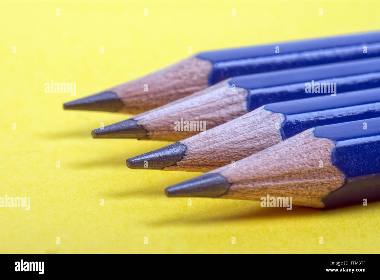 Four pronged pencils on yellow background Stock Photo - Alamy