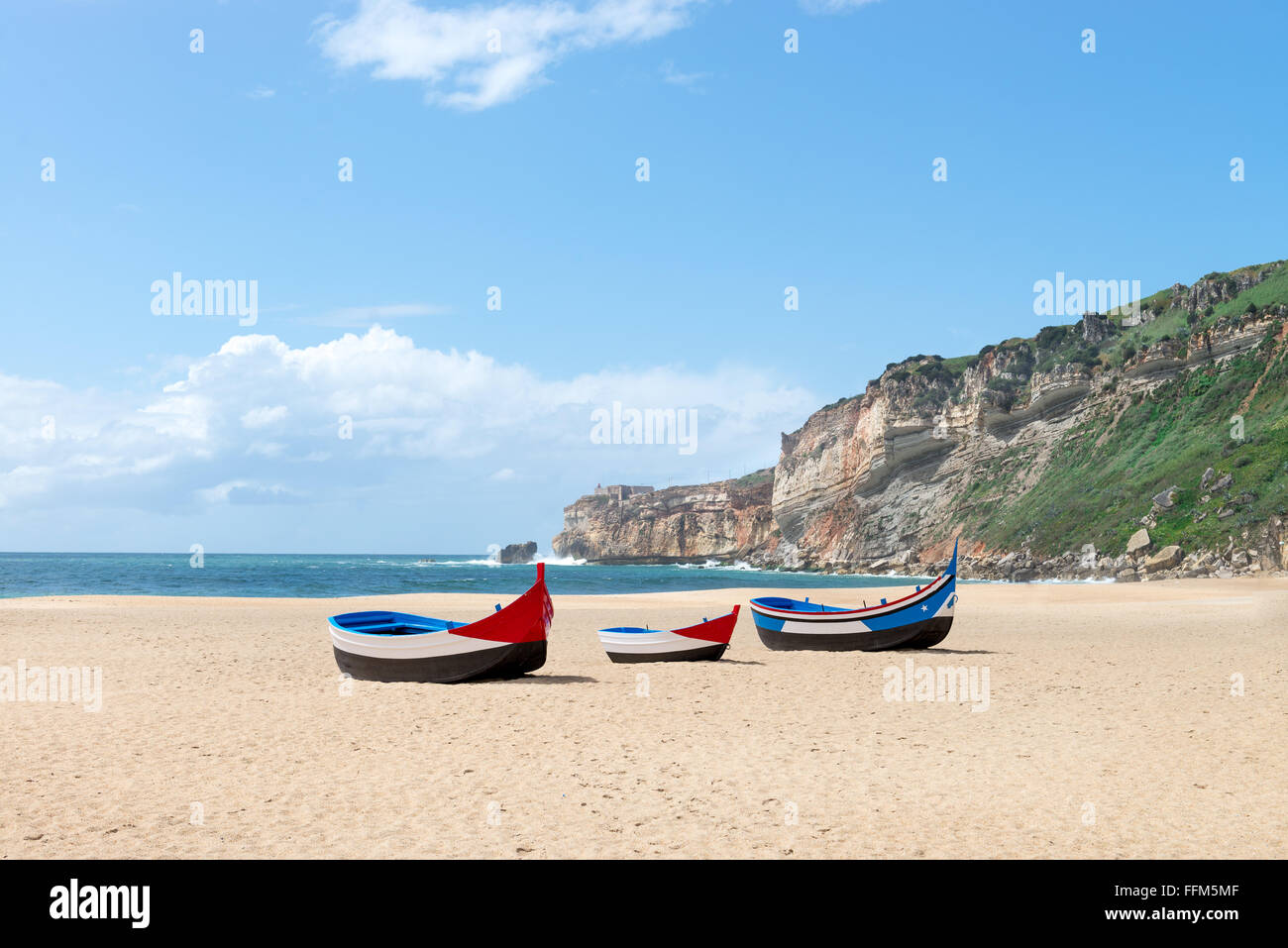 Main beach in Nazare with Traditional colorful boat on the sand ...