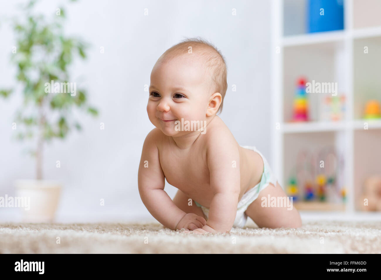 Adorable baby crawling on floor in the nursery Stock Photo - Alamy