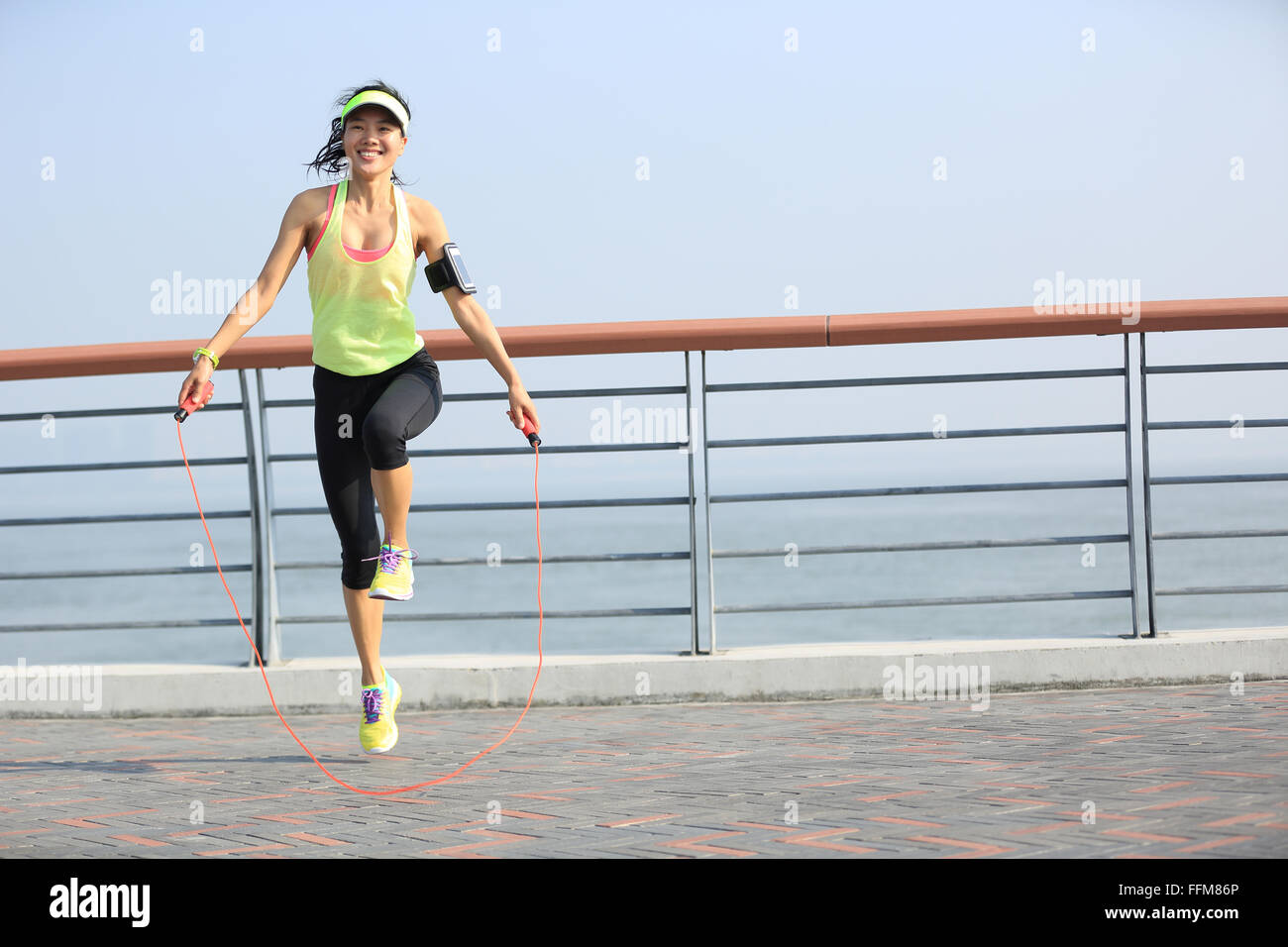 young fitness woman jumping rope at seaside Stock Photo - Alamy