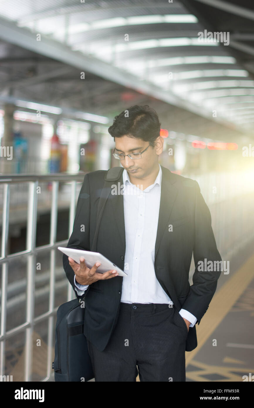 india male using tablet computer at train station Stock Photo - Alamy
