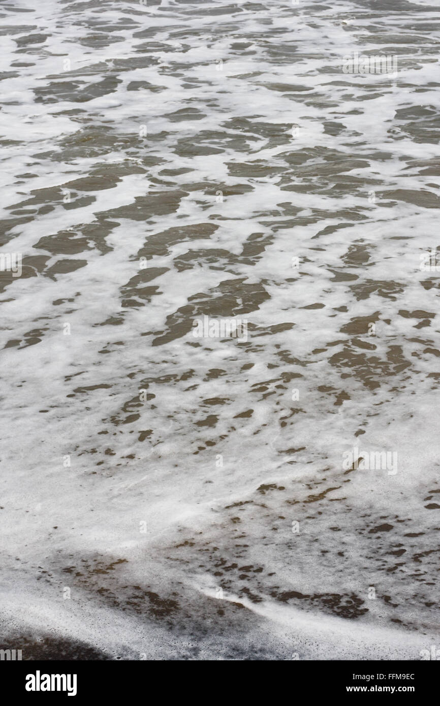 Frothy and foamy sea waves on a tropical beach Stock Photo - Alamy