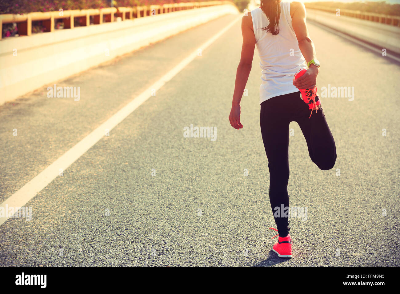 young fitness woman runner stretching legs before run Stock Photo - Alamy