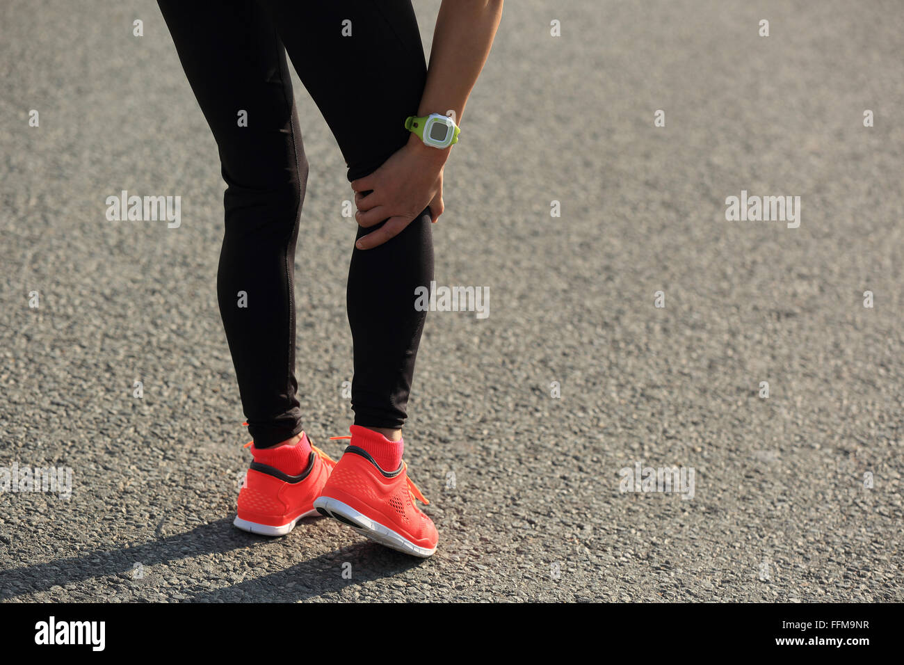 woman runner hold her injured leg on road Stock Photo - Alamy