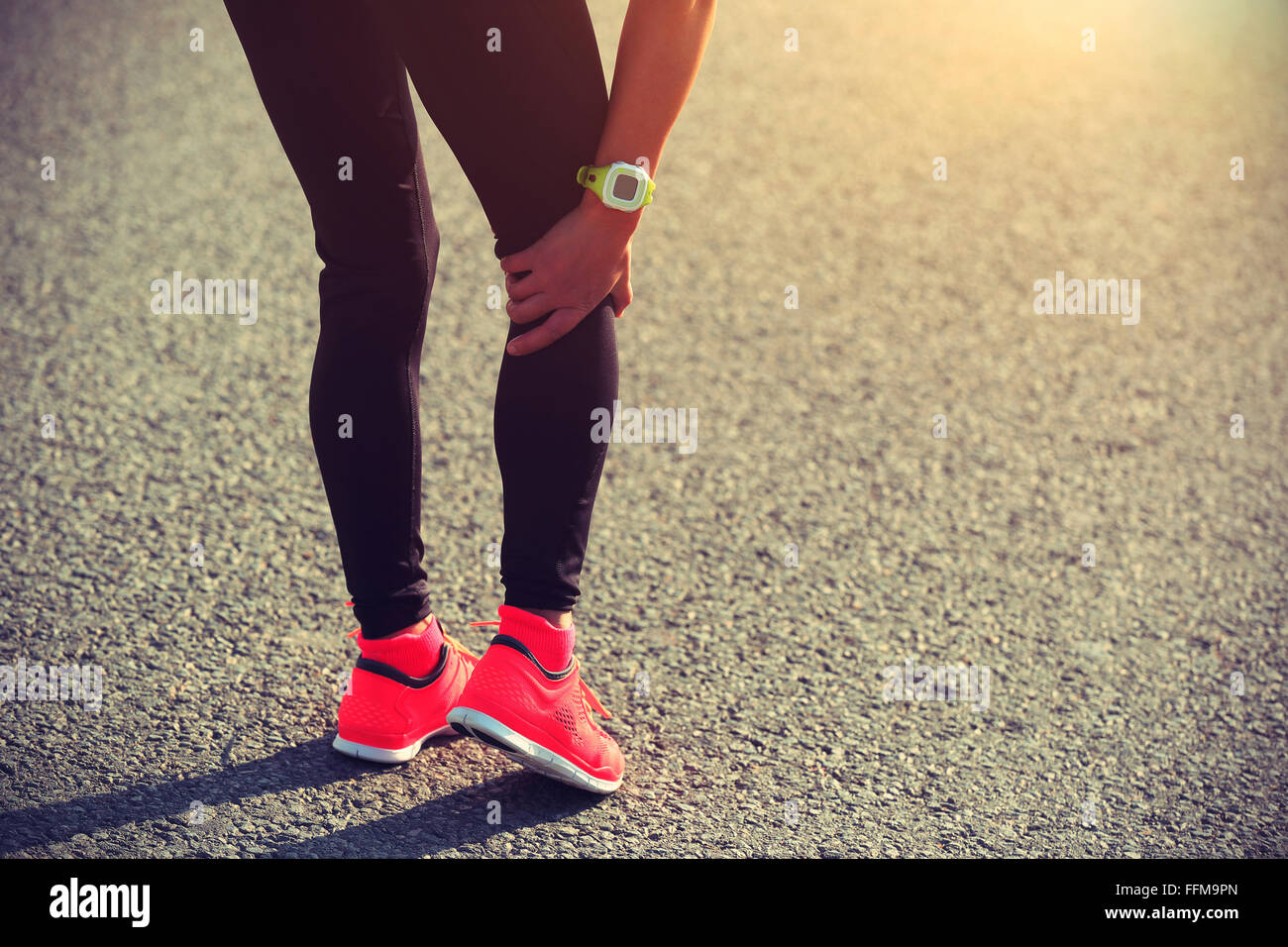 woman runner hold her injured leg on road Stock Photo - Alamy