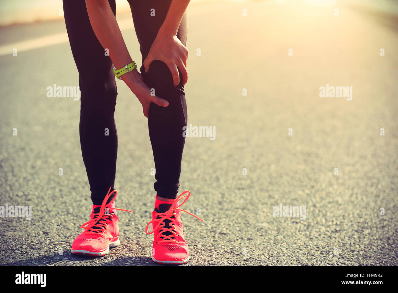 woman runner hold her injured leg on road Stock Photo - Alamy