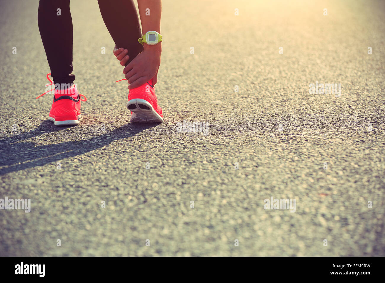 woman runner hold her injured leg on road Stock Photo - Alamy