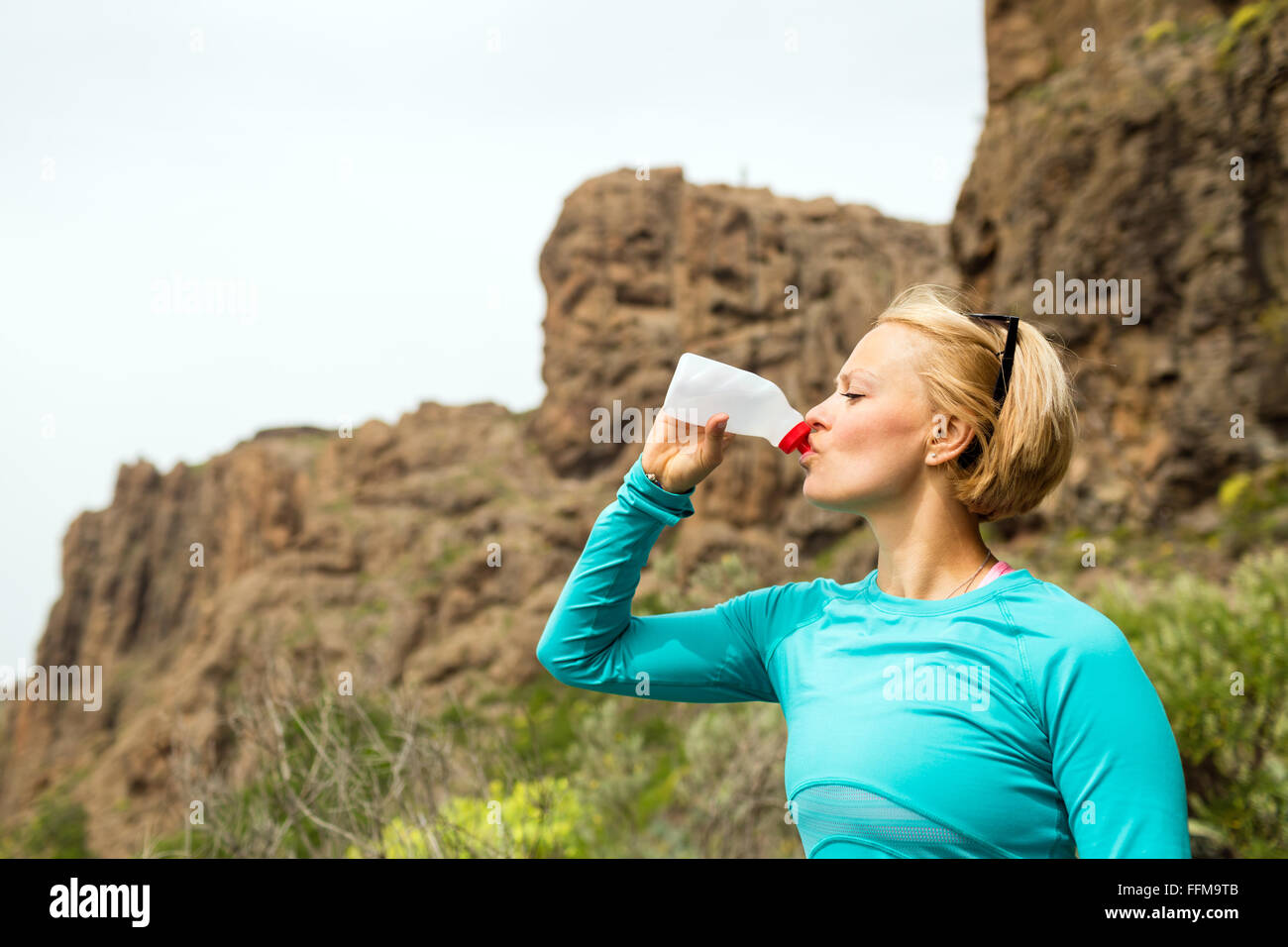 Trail runner woman cross country running and drinking water in ...