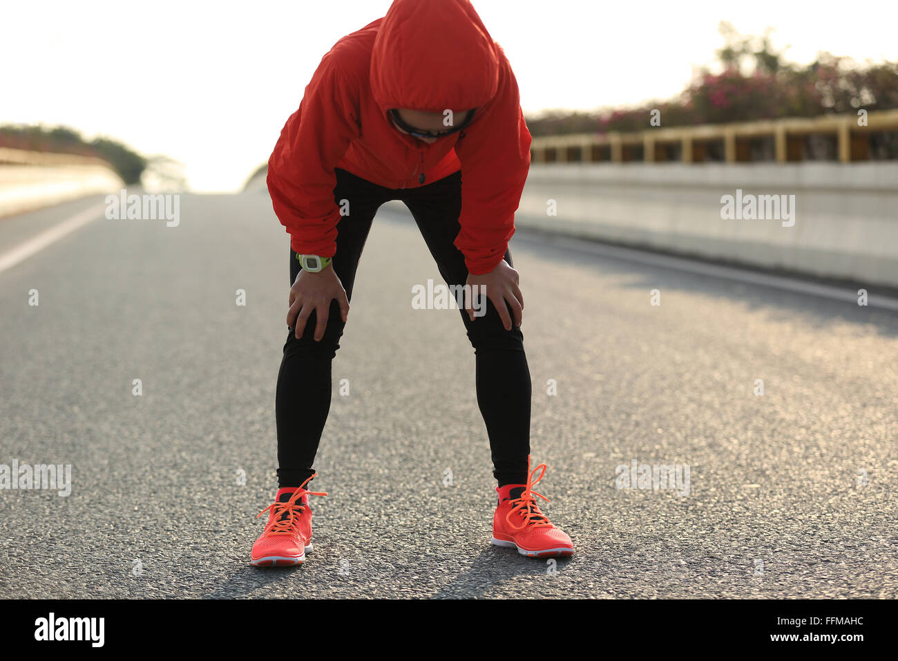 tired woman runner taking a rest after running hard on city road Stock ...