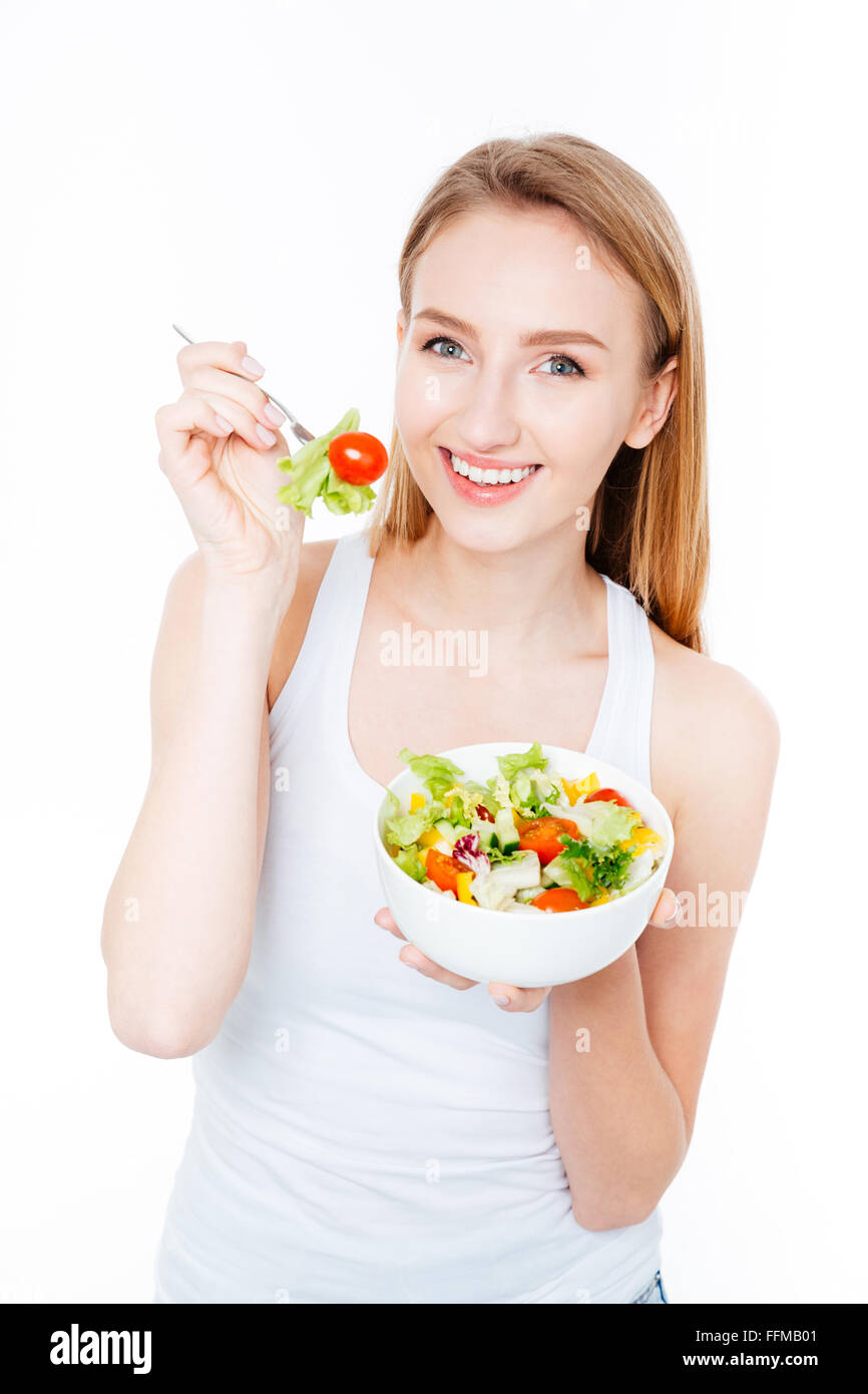 Smiling woman eating salad isolated on a white background Stock Photo ...