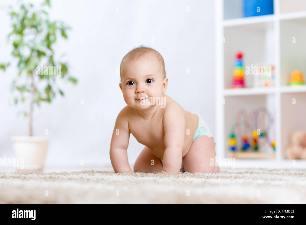 happy baby child smiling and crawling on floor in nursery Stock Photo ...
