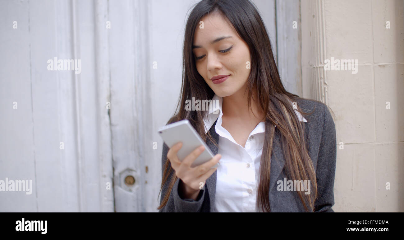 Attractive young woman sending a text message Stock Photo - Alamy