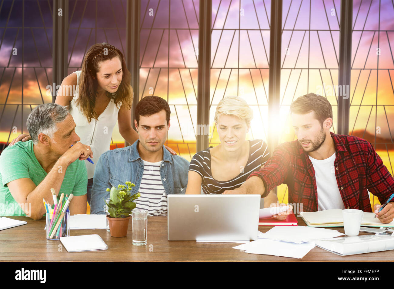 Composite image of teamwork using laptop together Stock Photo - Alamy