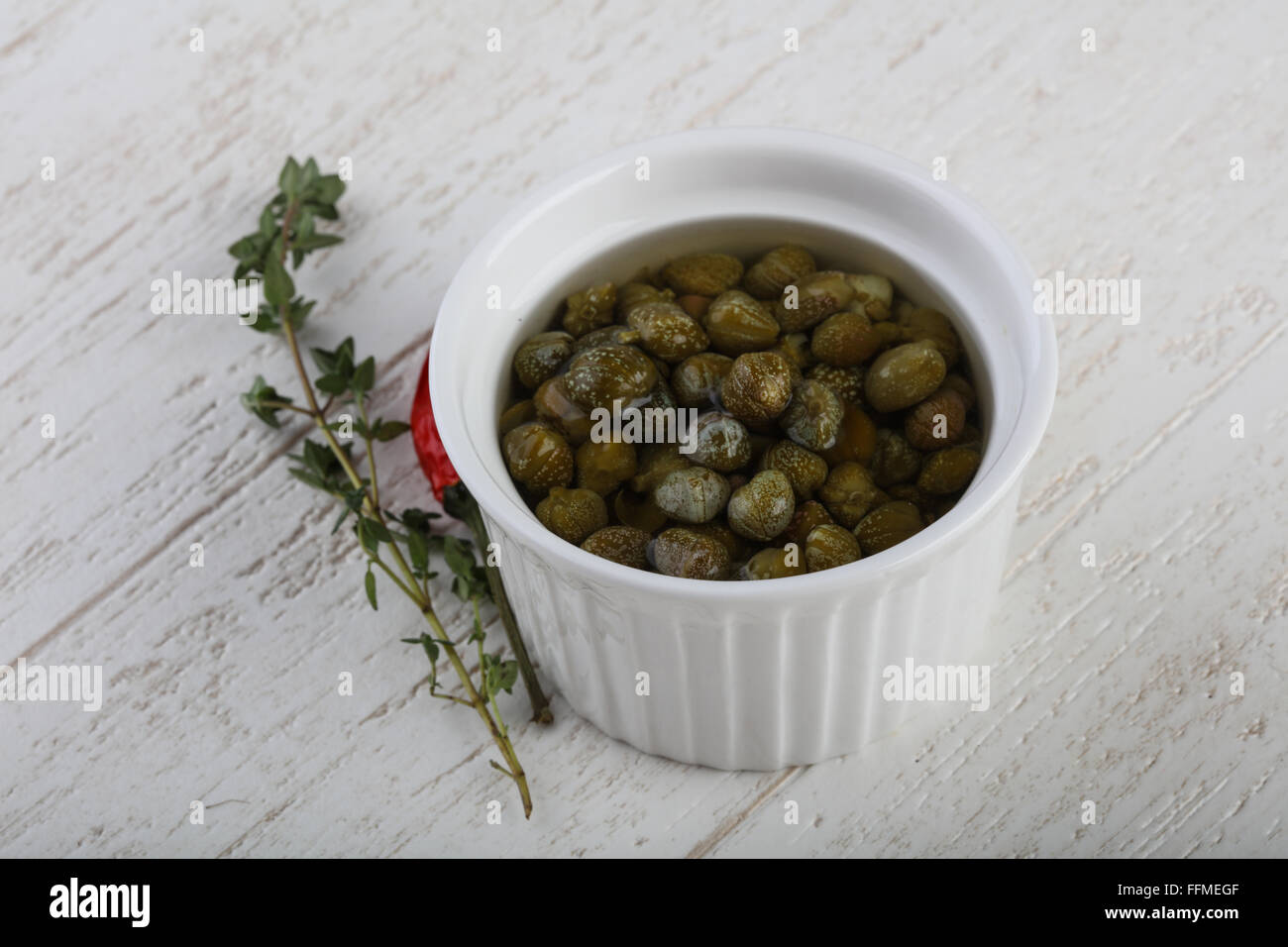 Pickled capers in the bowl on wood background Stock Photo - Alamy