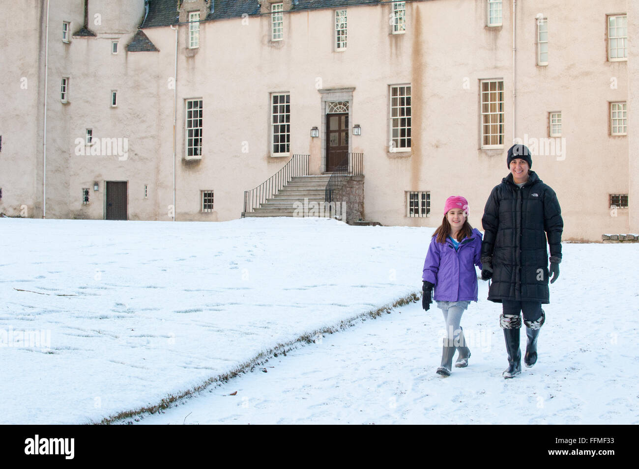 Mother and daughter walk in the snow at Drum Castle in Aberdeenshire ...