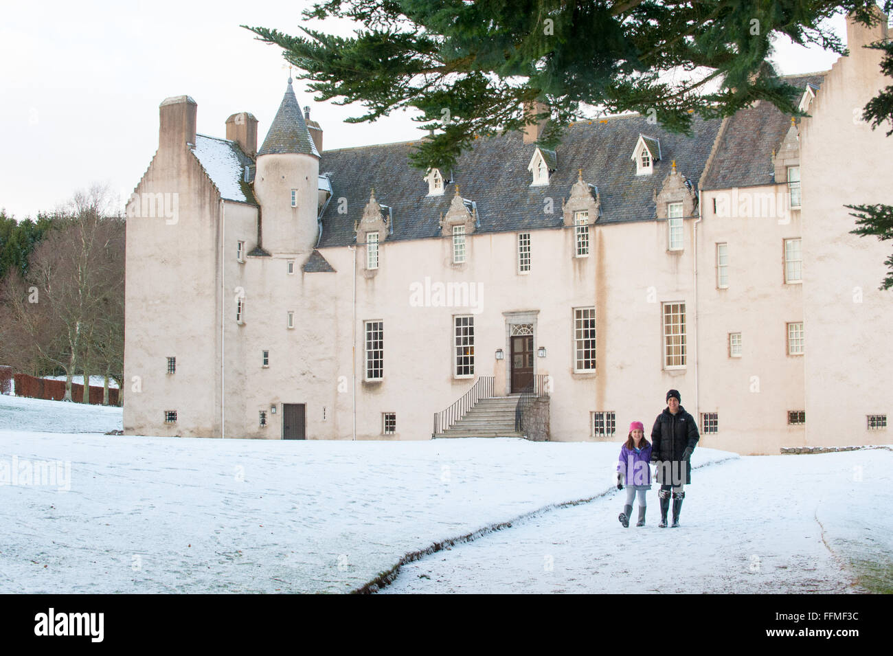 Mother and daughter walk in the snow at Drum Castle in Aberdeenshire ...
