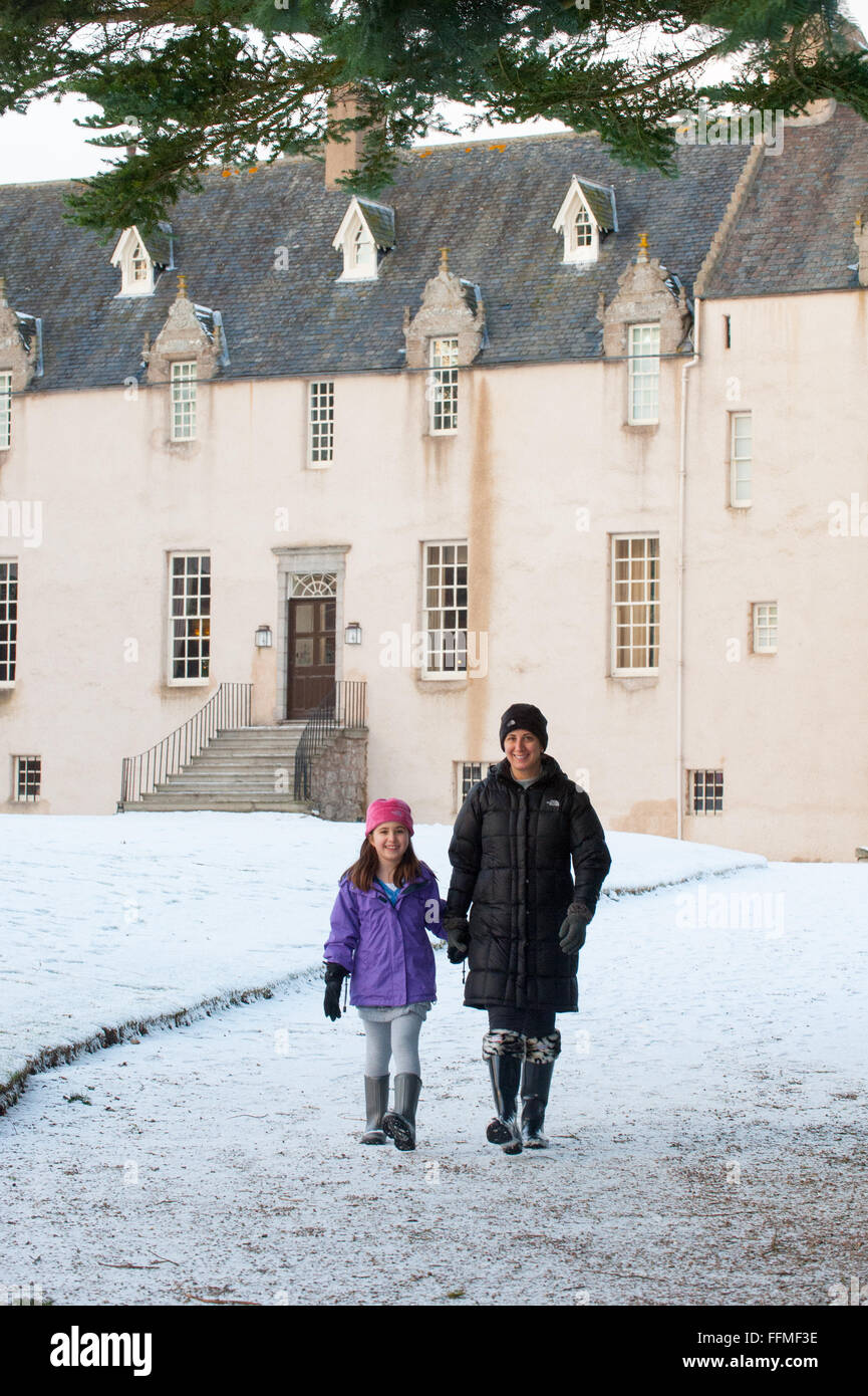 Mother and daughter walk in the snow at Drum Castle in Aberdeenshire ...